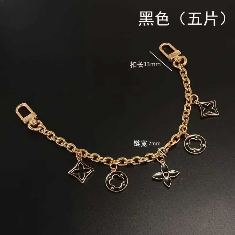 Metallic chain bag with black and white color and gold-tone hand-held ...